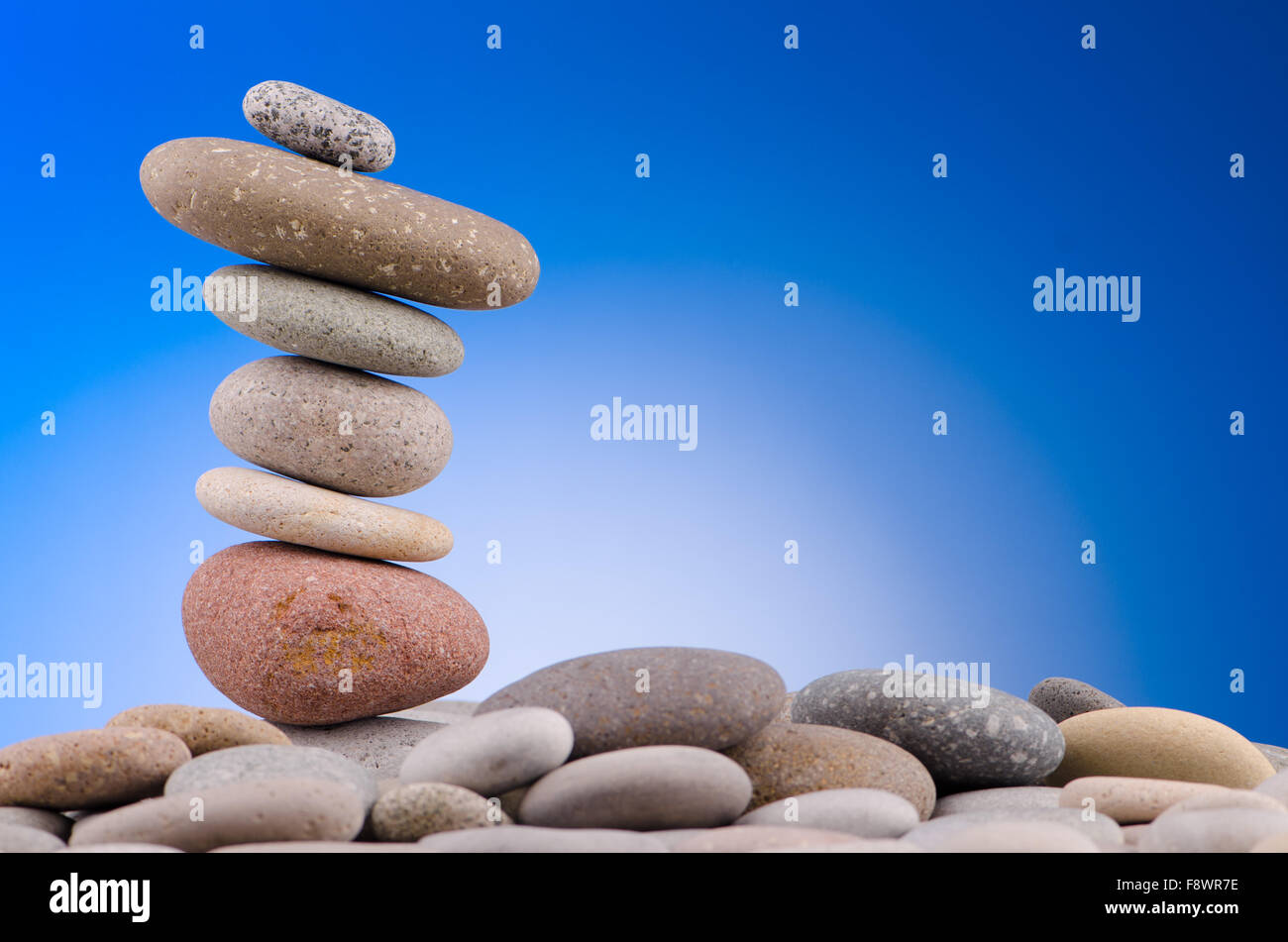 Pebbles stack against gradient background Stock Photo - Alamy