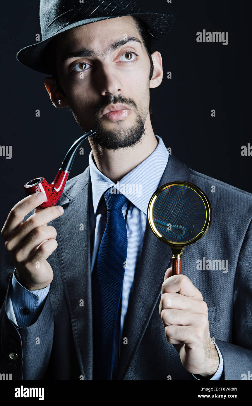 Detective with magnifying glass and pipe Stock Photo - Alamy