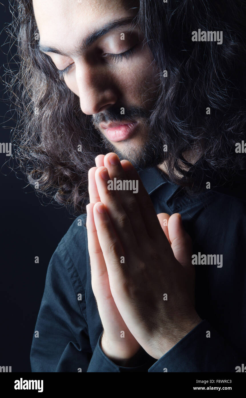 Young man praying in darkness Stock Photo - Alamy