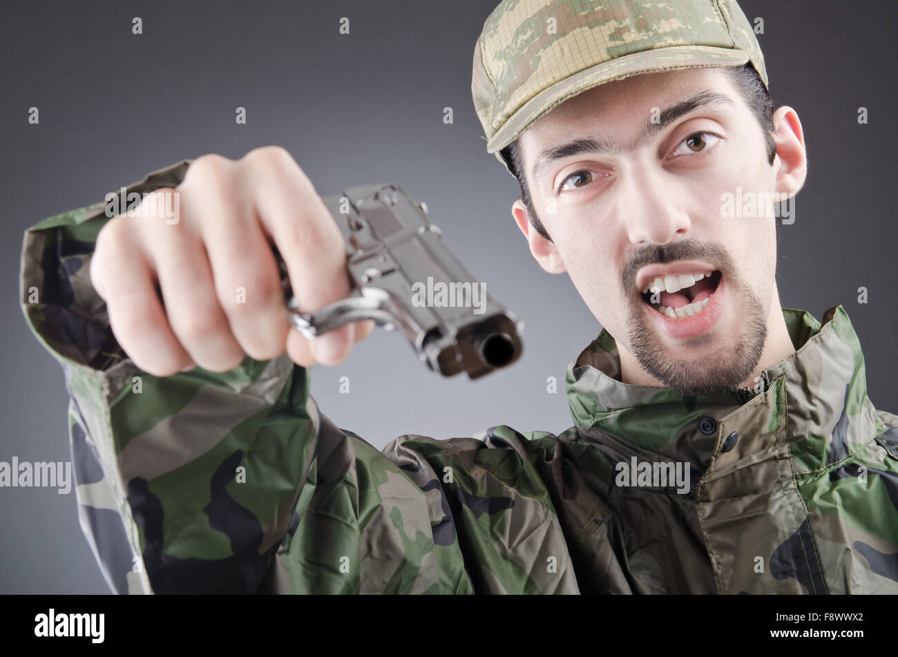 Soldier with gun in studio shooting Stock Photo - Alamy