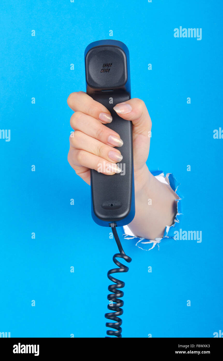 Hand with phone out of paper hole Stock Photo - Alamy