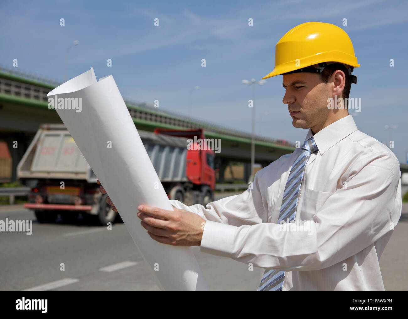 Architect looking at blueprint on construction site Stock Photo - Alamy