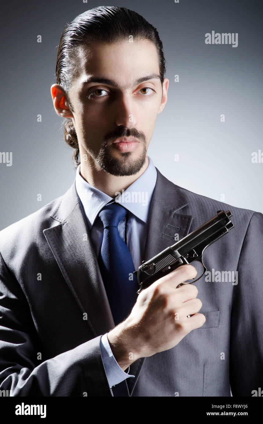 Businessman man with hand gun Stock Photo - Alamy