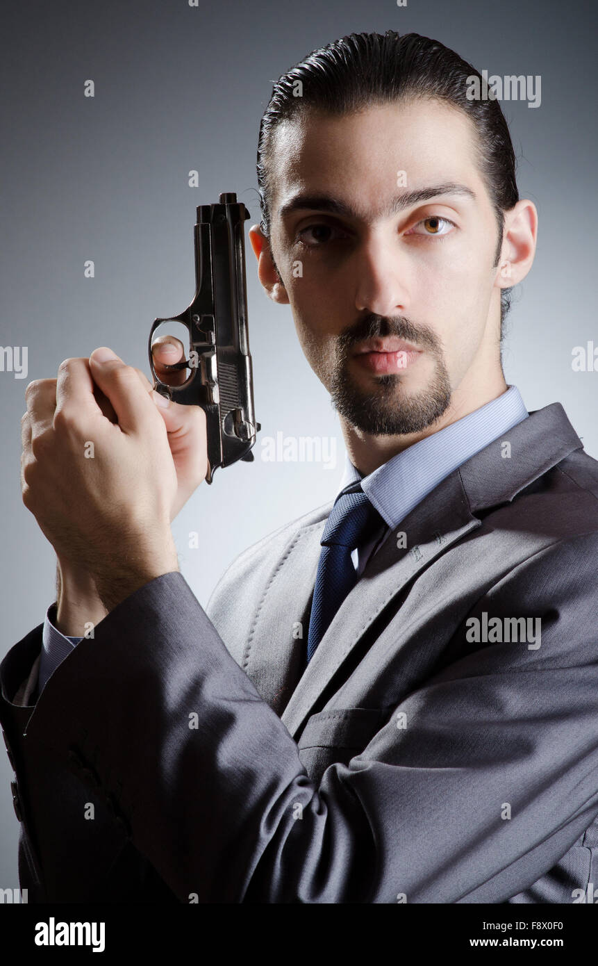Businessman man with hand gun Stock Photo - Alamy
