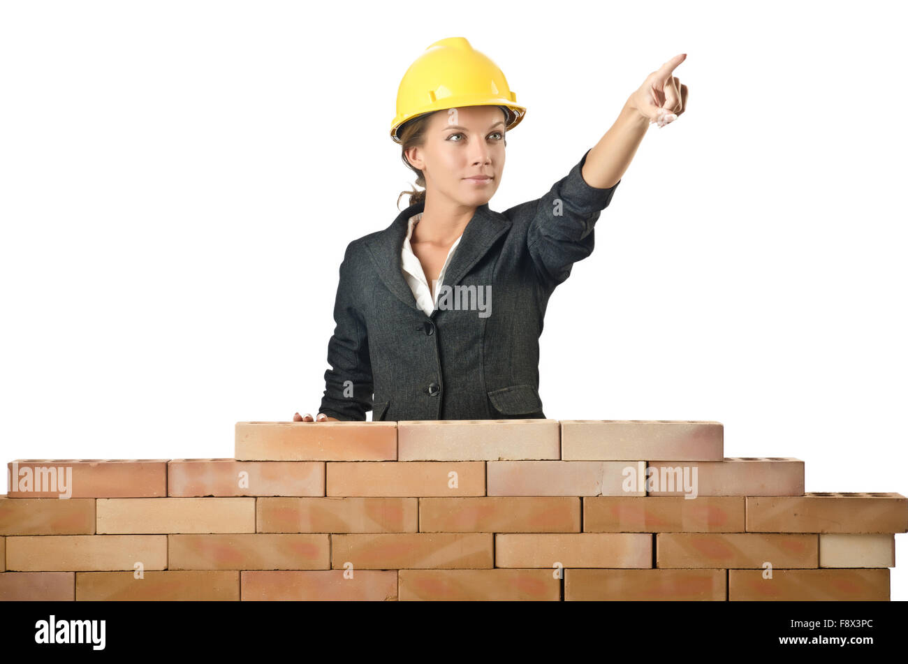 Young female builder near brick wall Stock Photo - Alamy