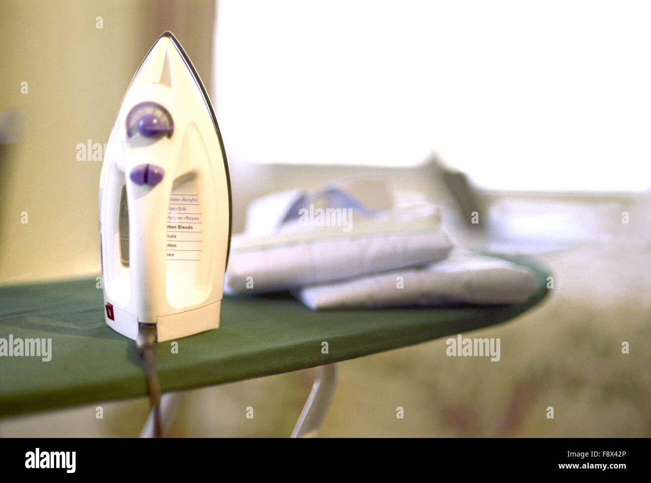 Iron Resting on Ironing Board Stock Photo - Alamy