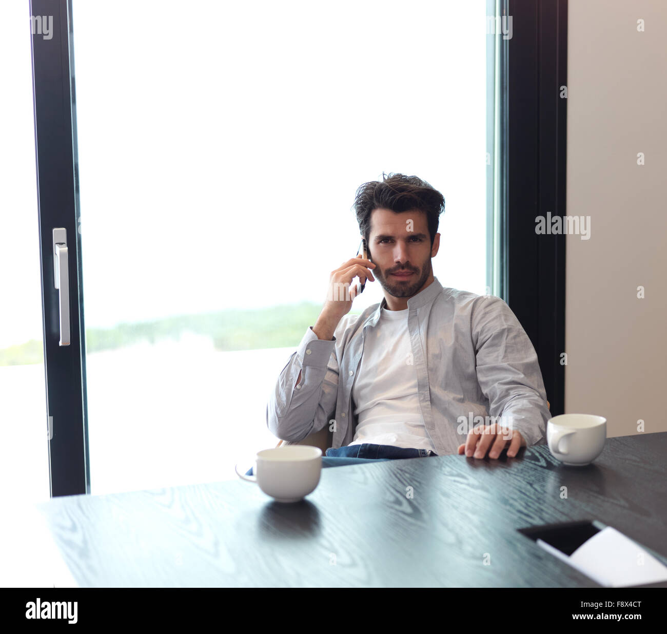 relaxed young man drink first morning coffee at modern home indoors ...