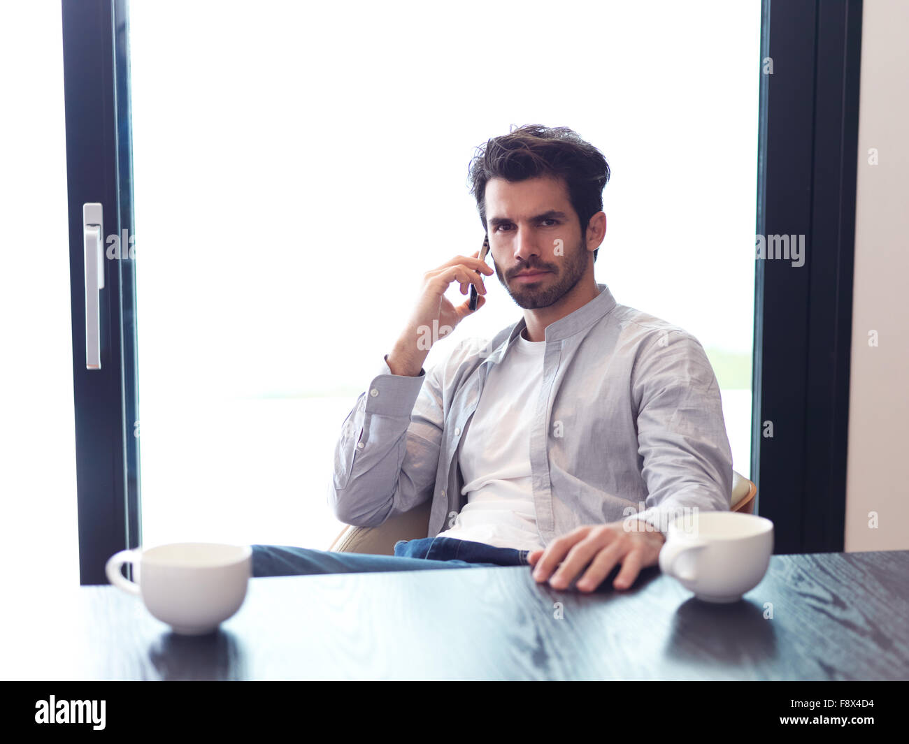 relaxed young man drink first morning coffee at modern home indoors ...