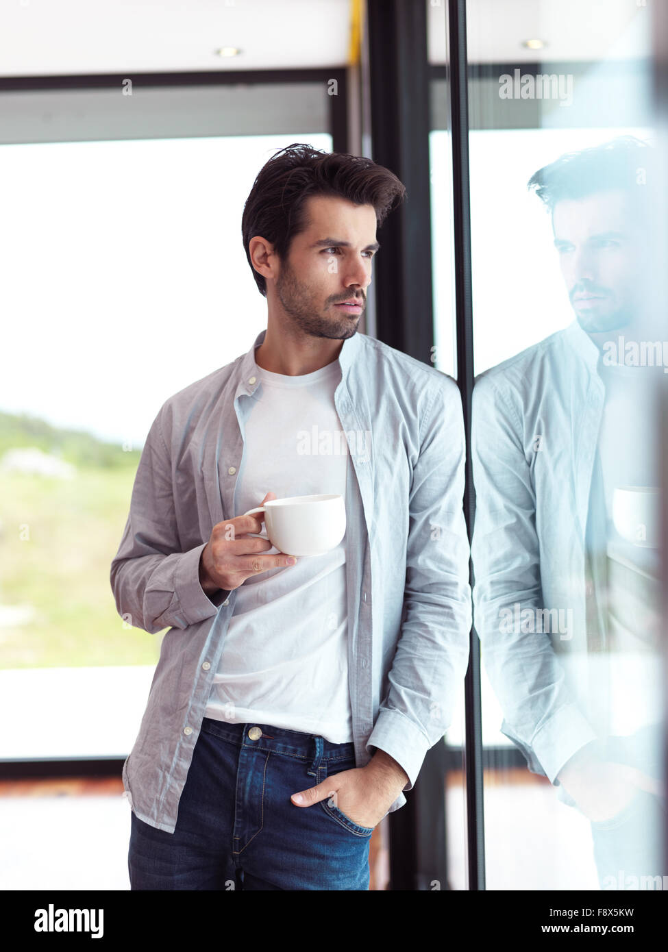 relaxed young man drink first morning coffee at modern home indoors ...