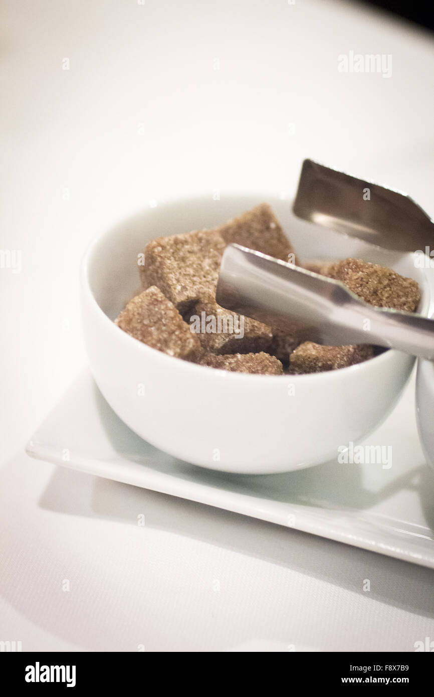 Sugar cubes in restaurant on white table cloth with tongs Stock Photo ...