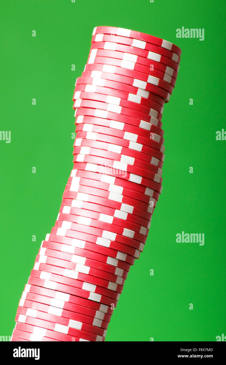 Stack of red casino chips against green background Stock Photo - Alamy