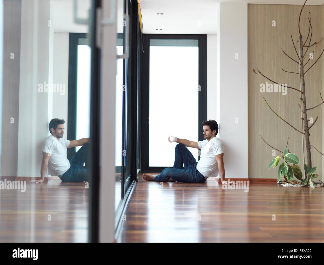 relaxed young man drink first morning coffee at modern home indoors ...