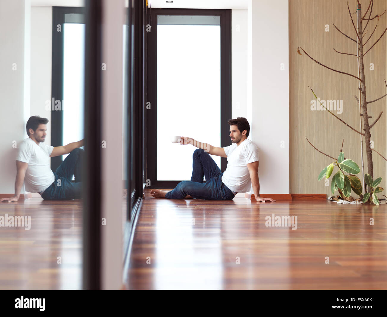 relaxed young man drink first morning coffee at modern home indoors ...