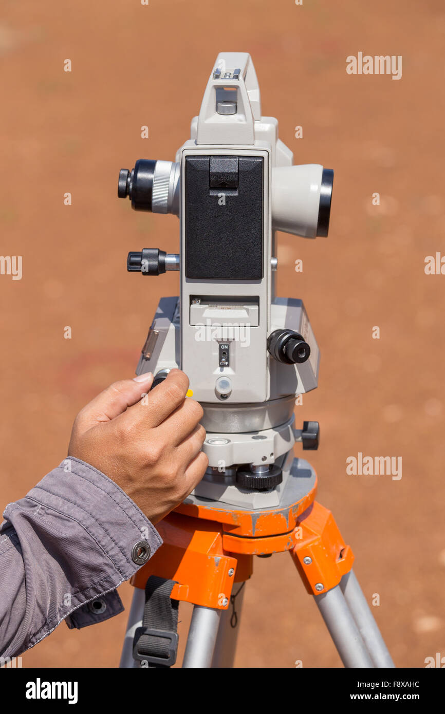 hand of engineer use tacheometer or theodolite for survey line columns ...