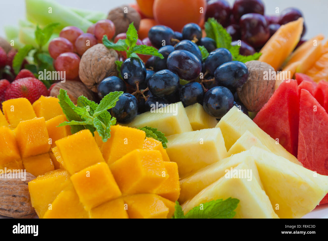 Colorful summer fruit platter with mango, pineapple, watermelon, grapes, cherries, apricots ...