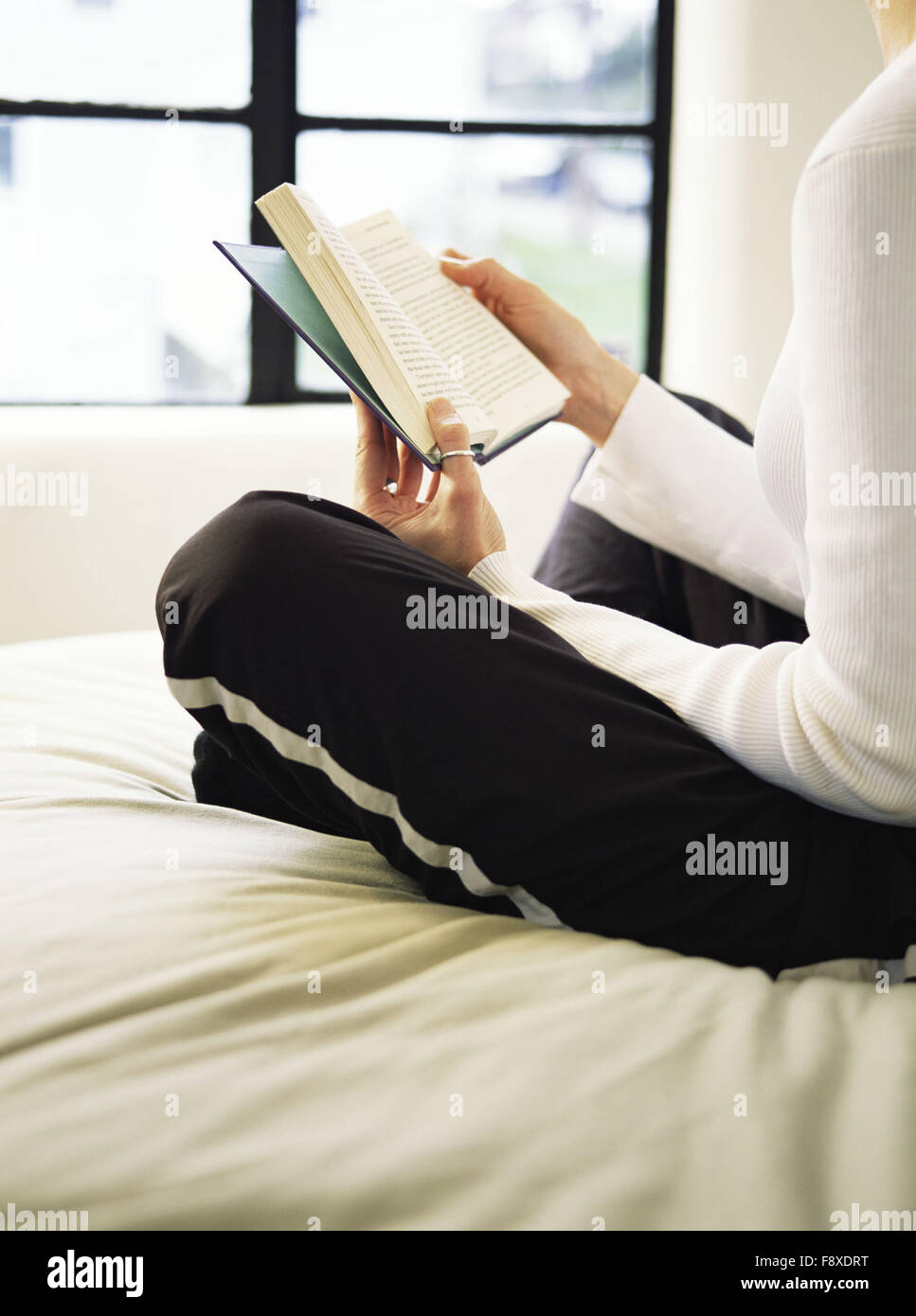 Reading a Book on Her Bed Stock Photo - Alamy
