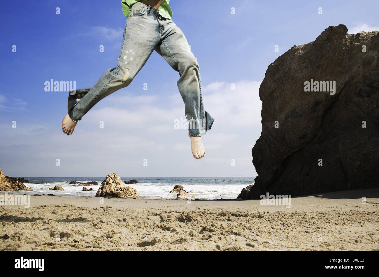 Legs of Man Jumping on Beach Stock Photo - Alamy
