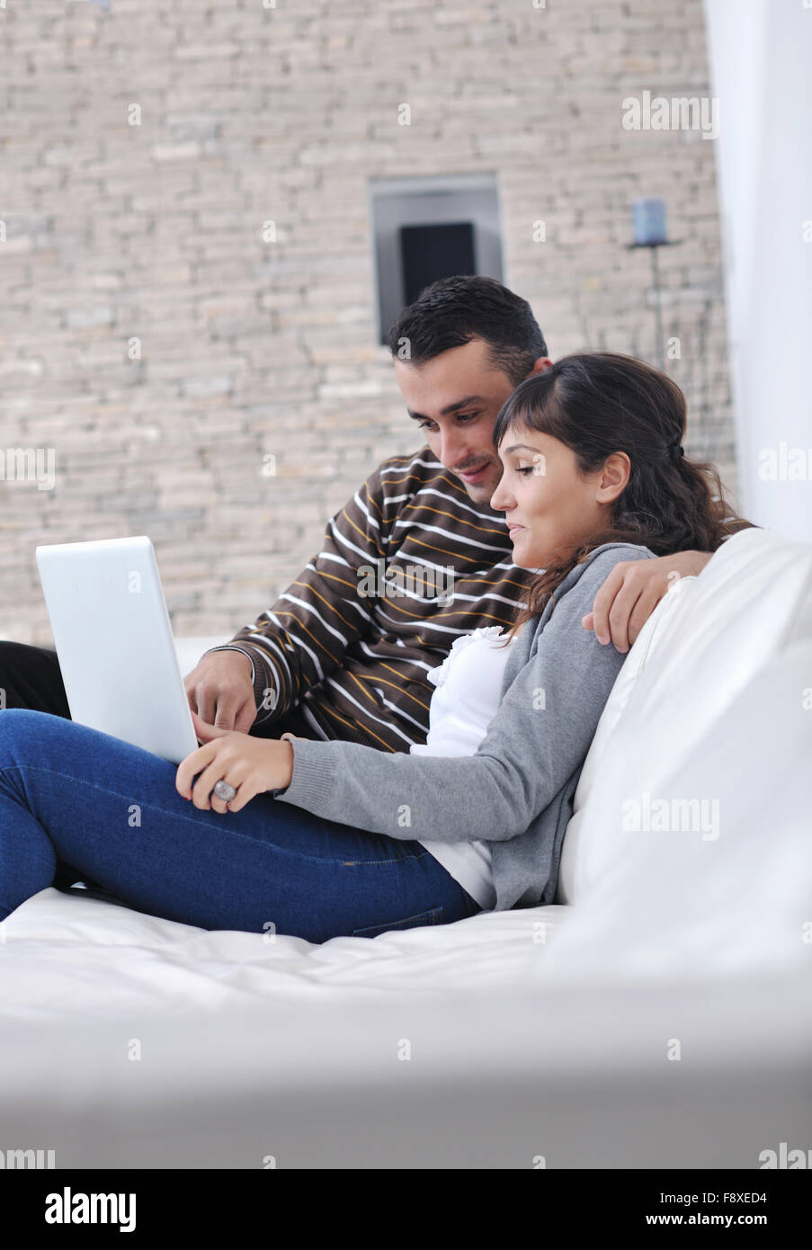 joyful couple relax and work on laptop computer at modern living room ...