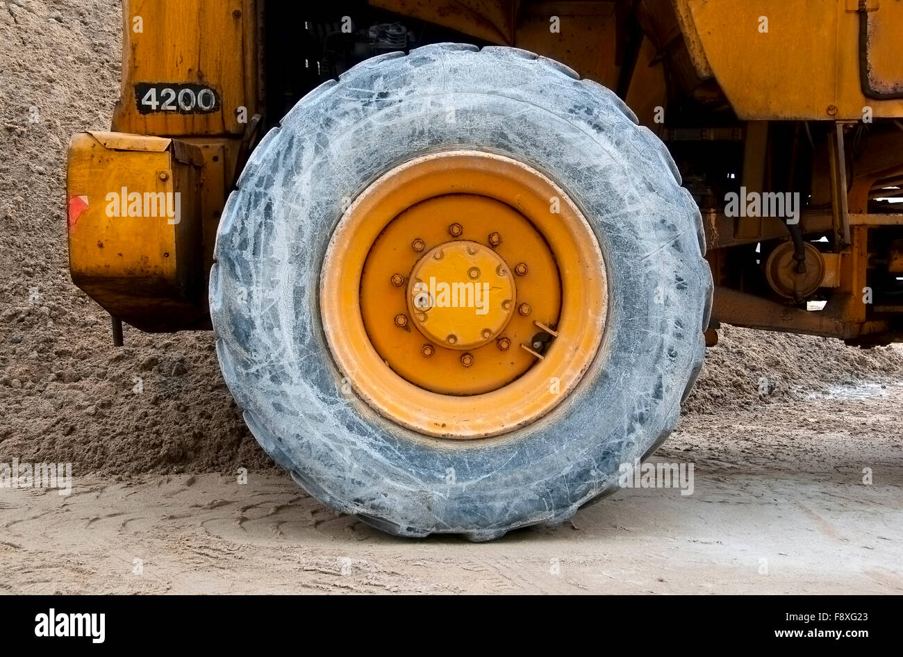 Wheel of backhoe / tractor over sand Stock Photo - Alamy