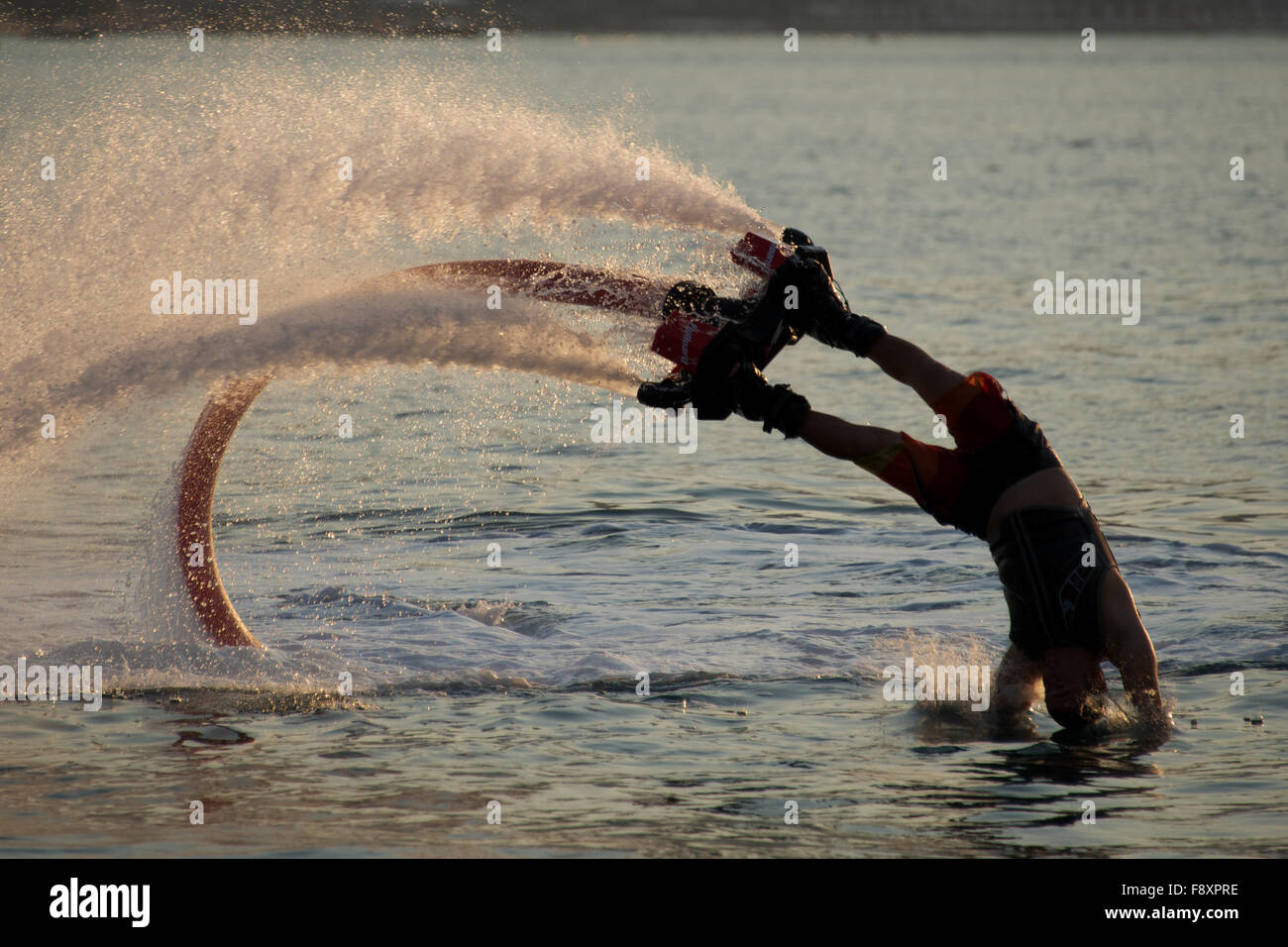 Flyboarder entering water leaving trail of spray Stock Photo - Alamy