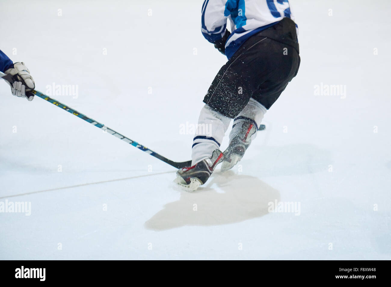 ice hockey player in action kicking with stick Stock Photo - Alamy