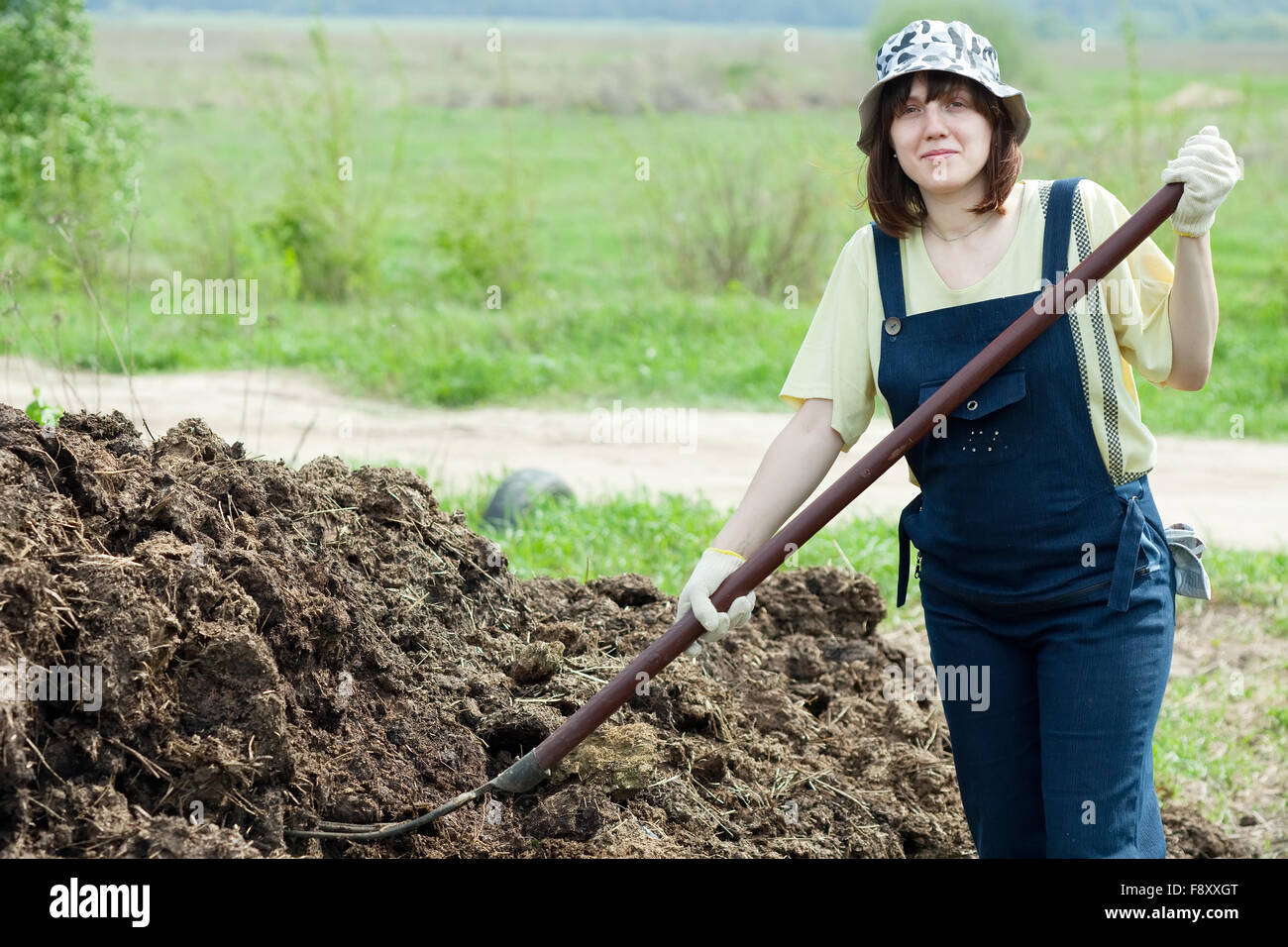 Female farmer spreads manure at farm Stock Photo - Alamy