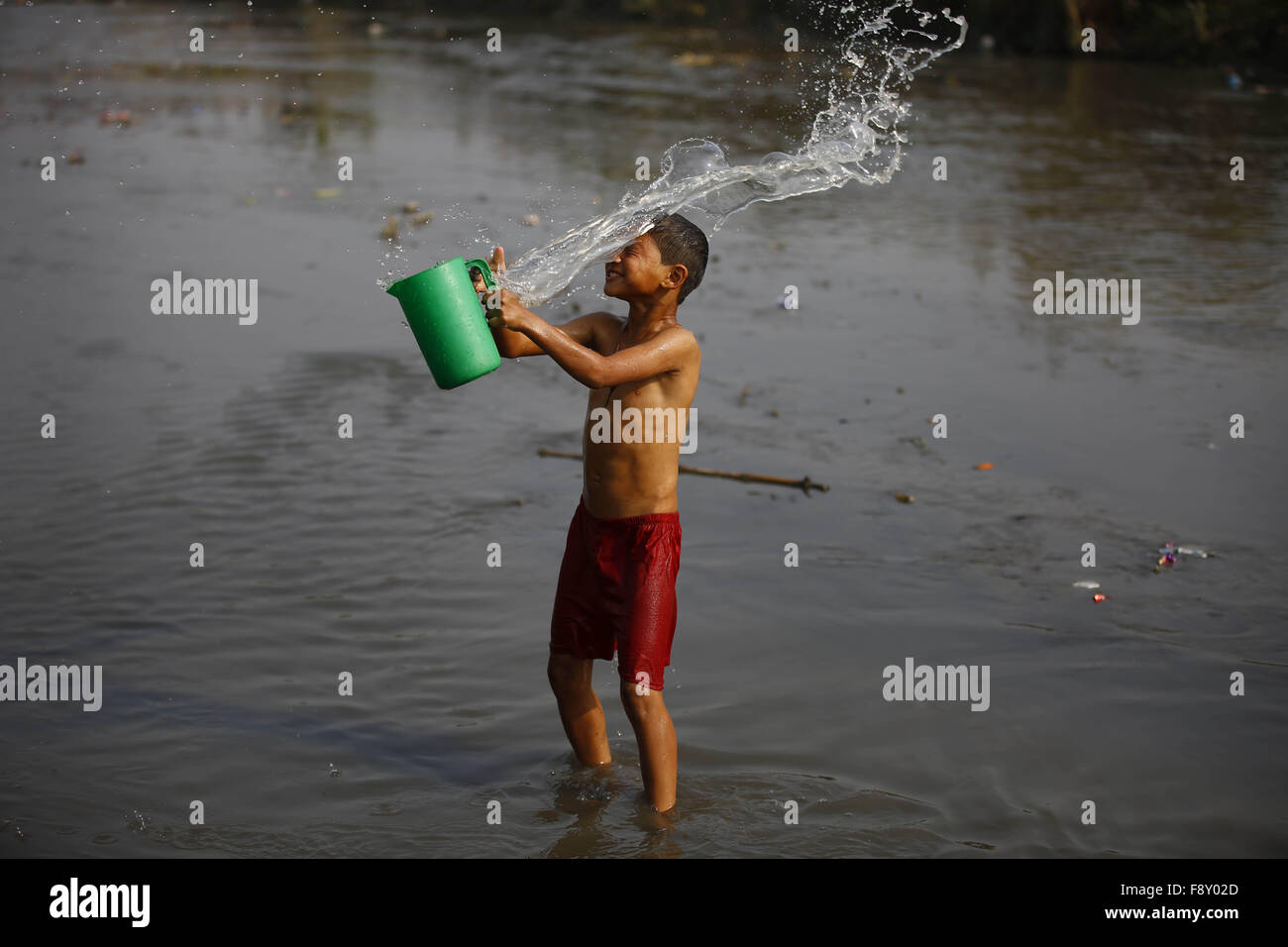 Kathmandu, Nepal. 12th Dec, 2015. A ten-year-old boy takes a bath under ...