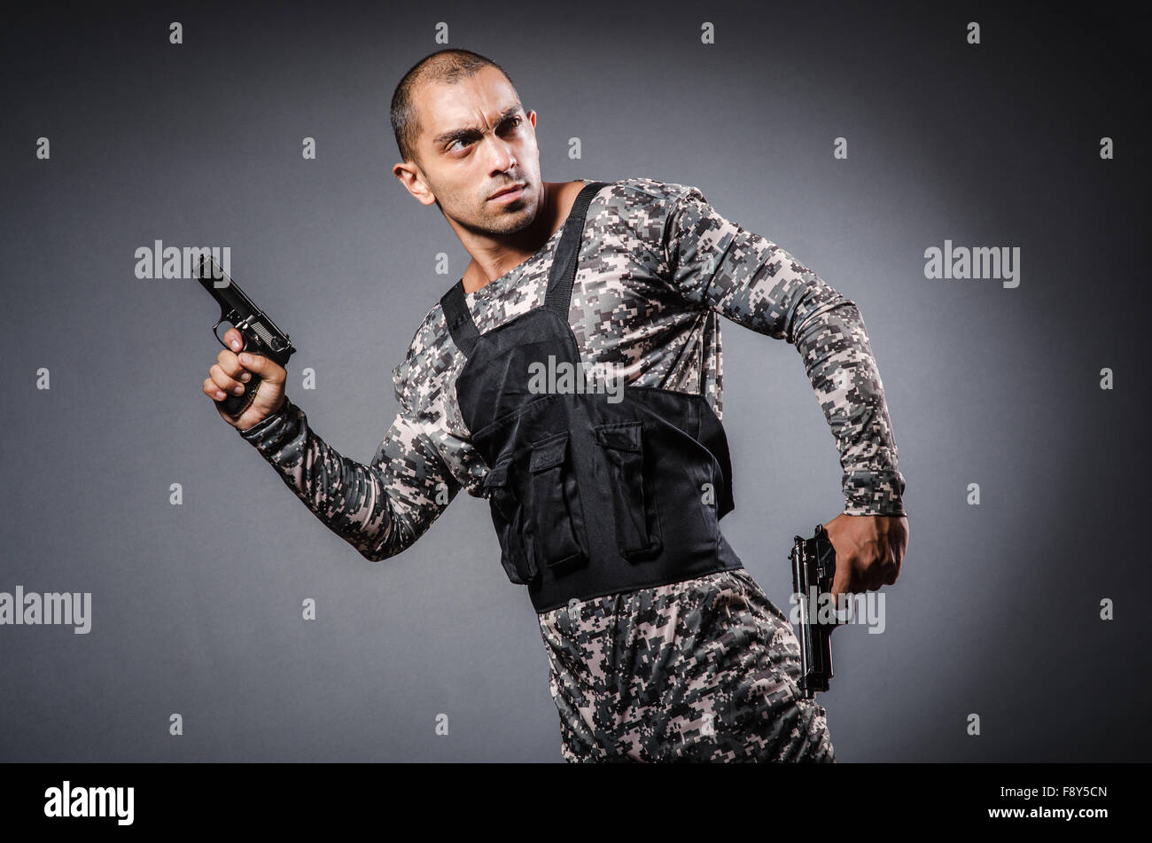 Soldier with guns against dark background Stock Photo - Alamy