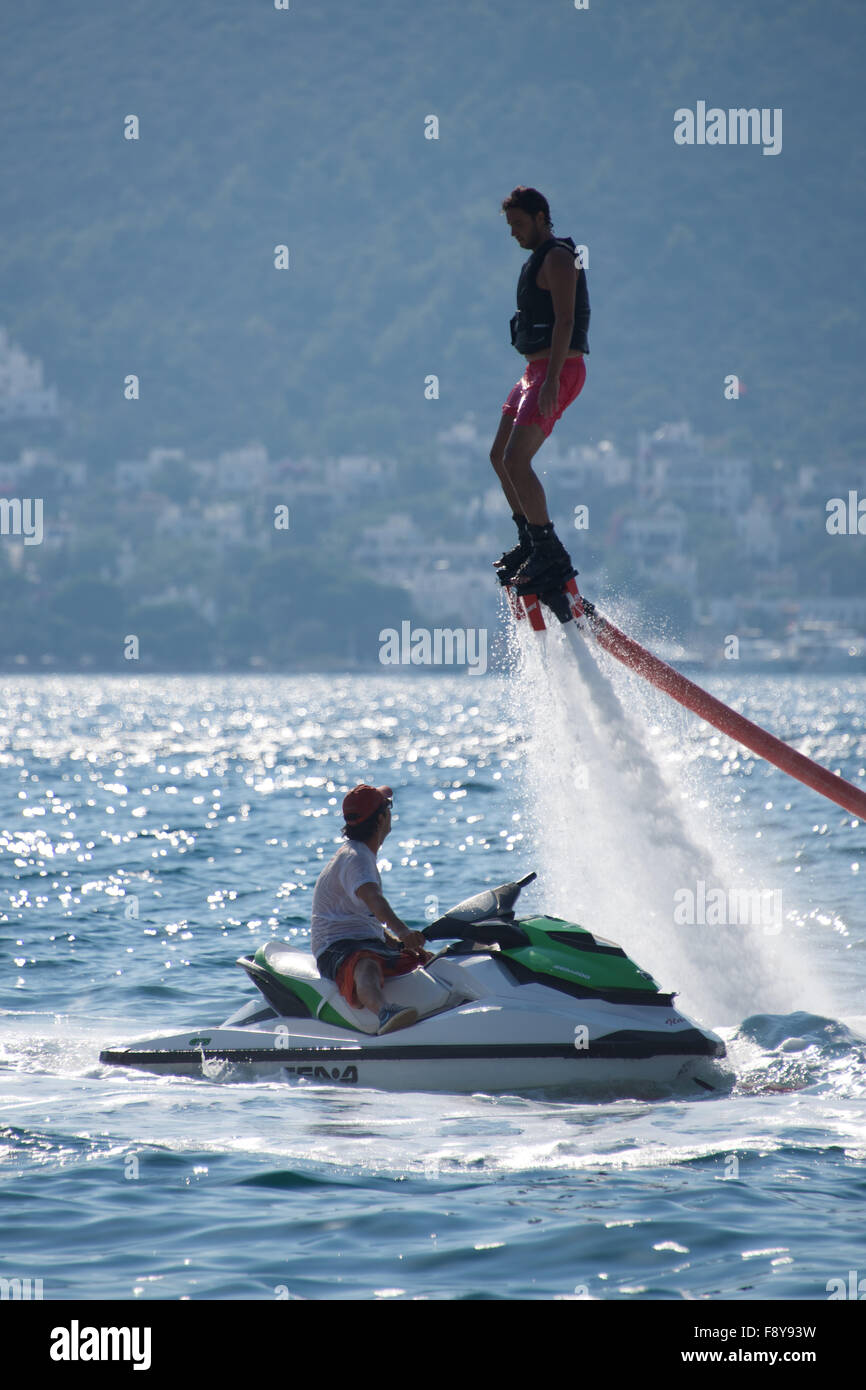 Flyboarder flying over man on Jet Ski Stock Photo - Alamy