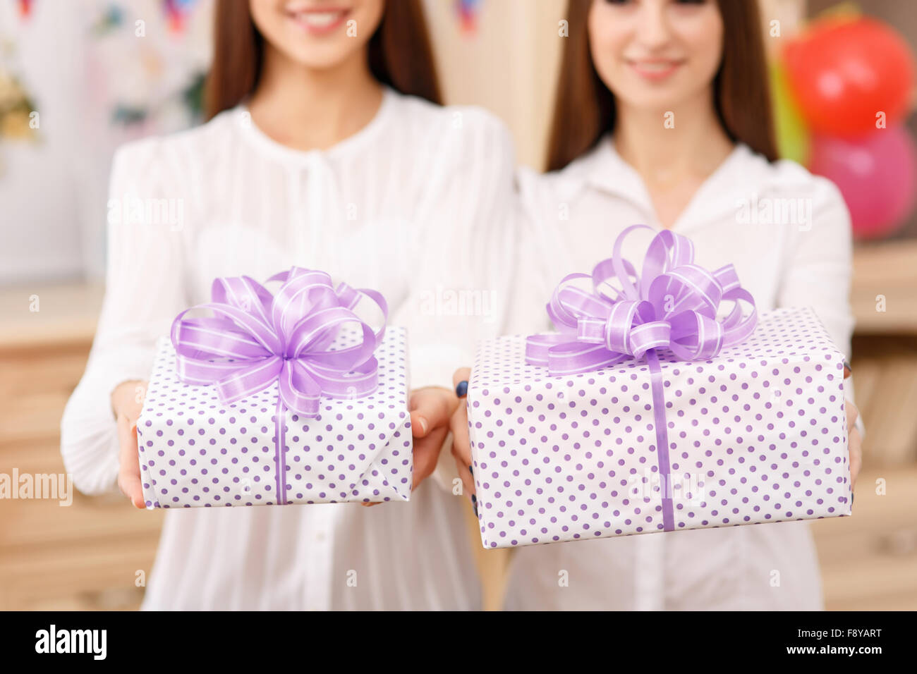 Two young ladies holding presents Stock Photo - Alamy