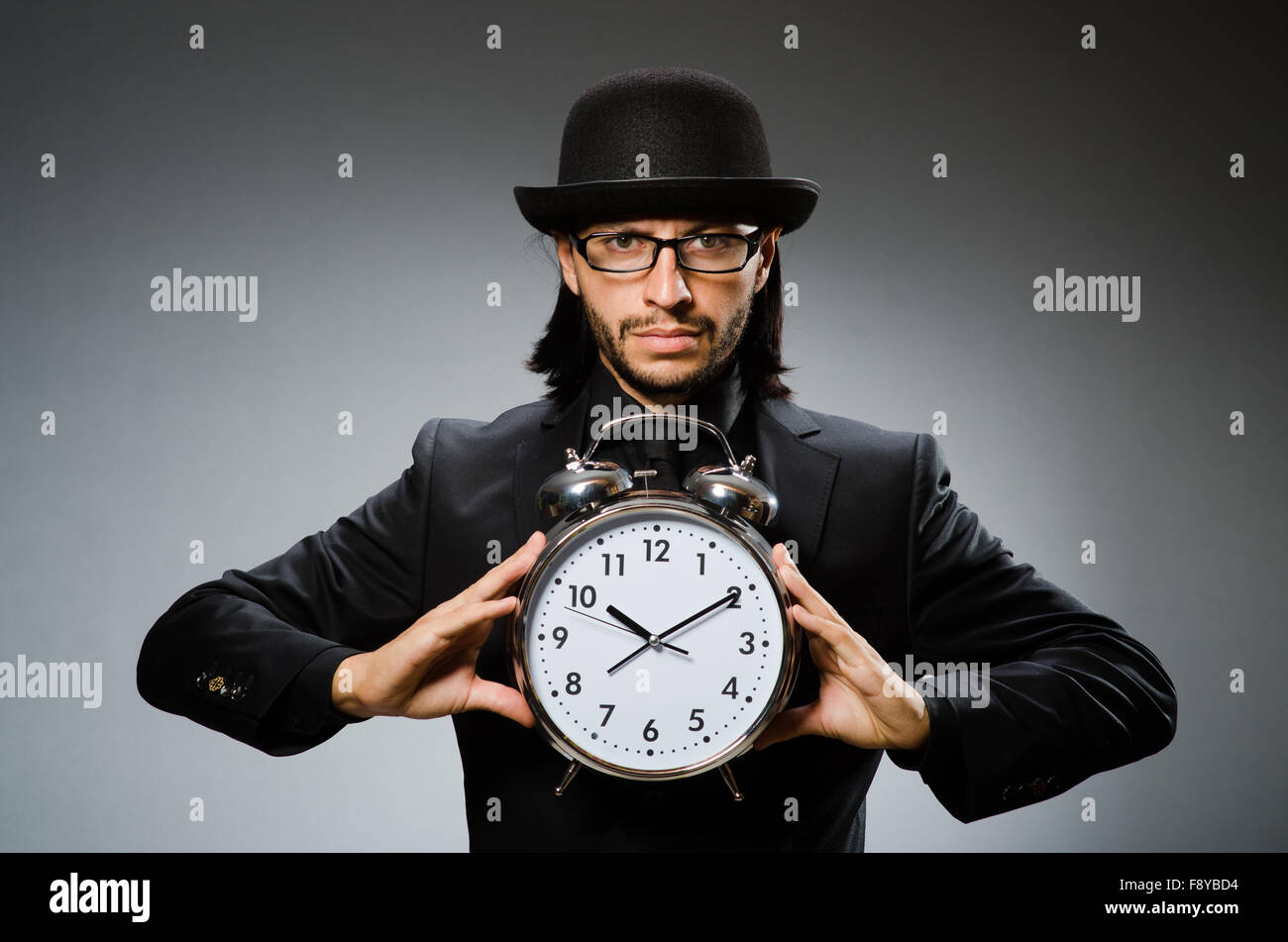 Man with clock wearing vintage hat Stock Photo - Alamy