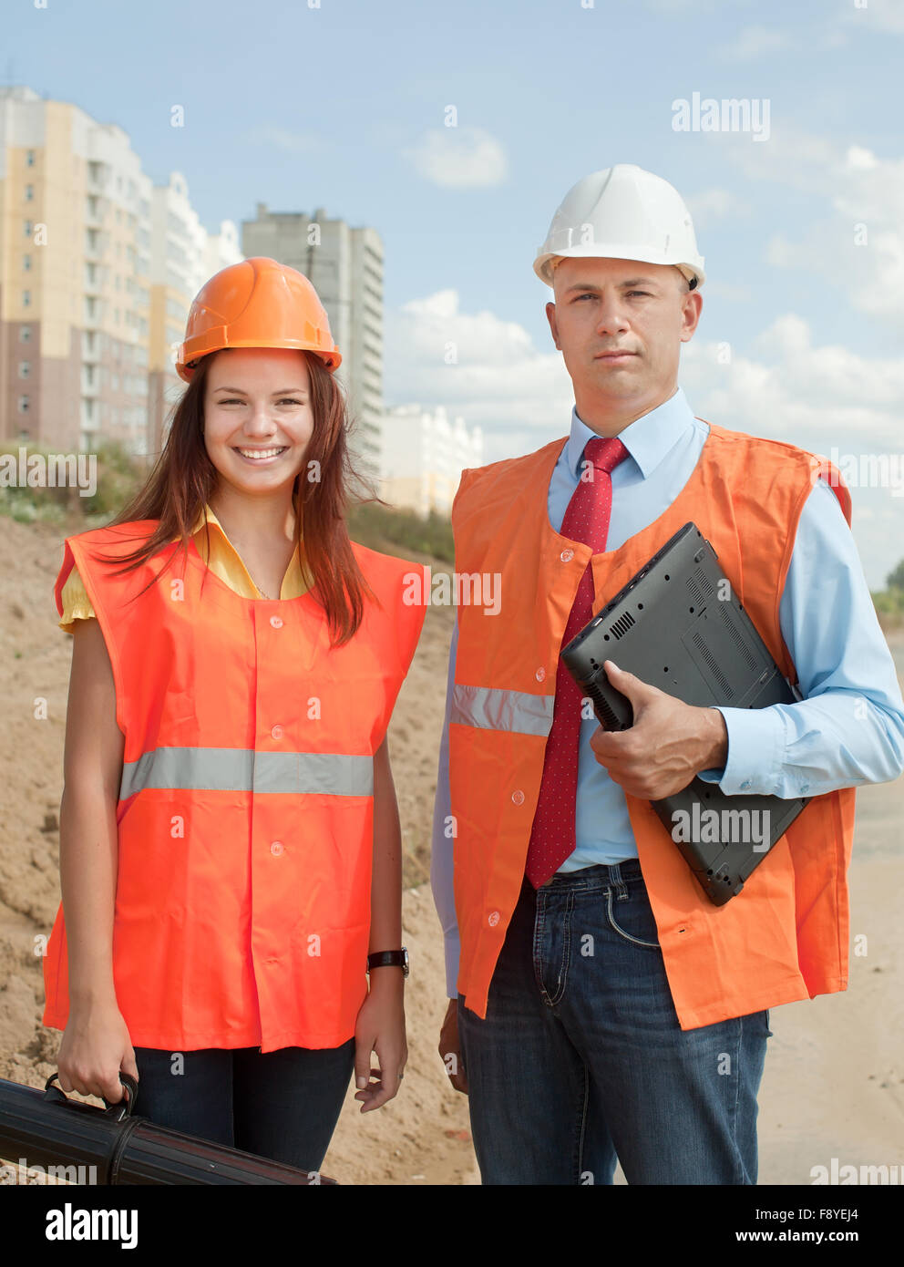 Portrait of two builders standing at building site Stock Photo - Alamy