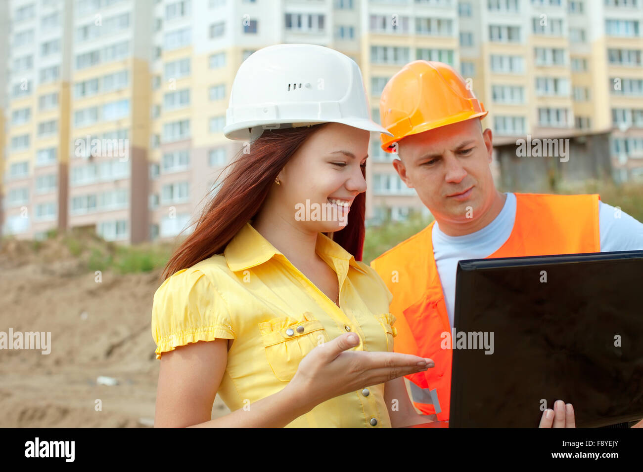 Portrait of two builders works at construction site Stock Photo - Alamy
