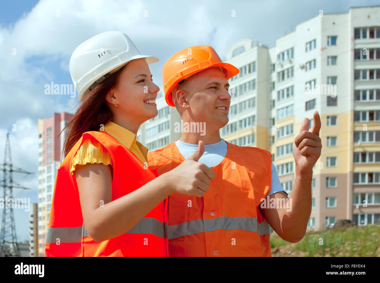 Portrait of two builders standing at building site Stock Photo - Alamy