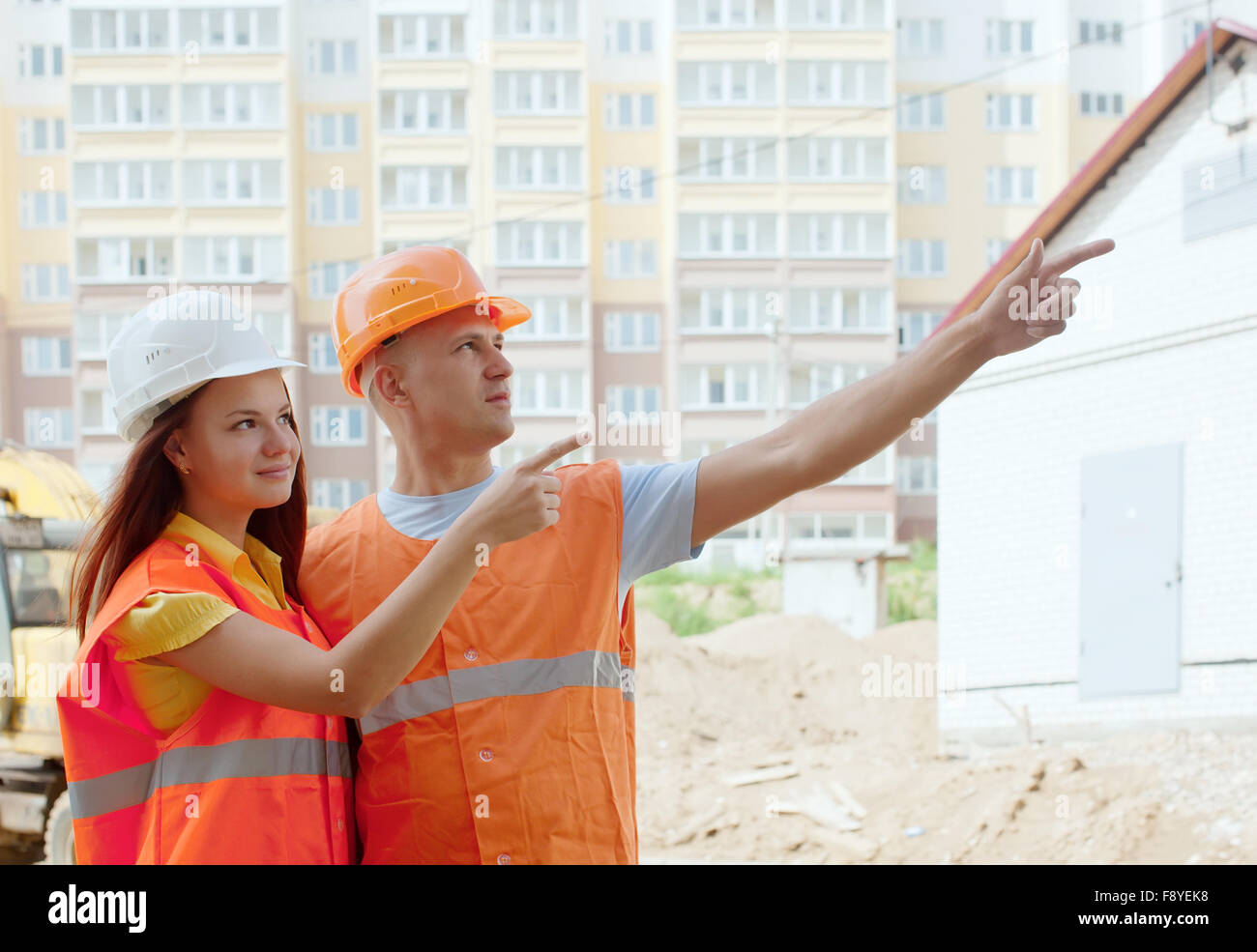Portrait of two builders standing at building site Stock Photo - Alamy