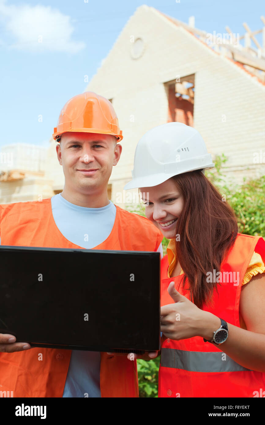Portrait of two builders works at building site Stock Photo - Alamy