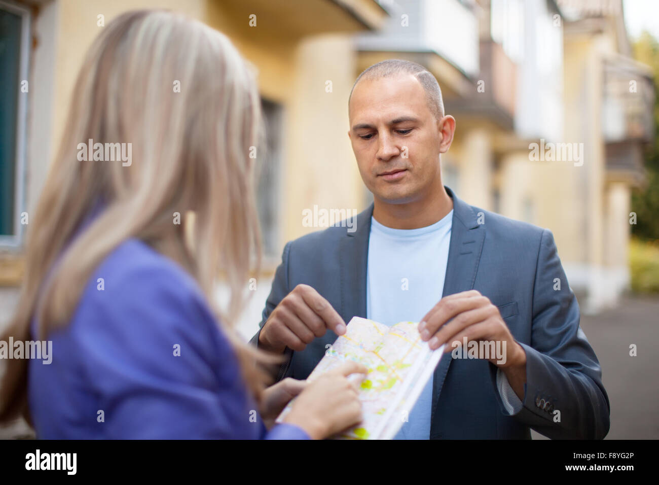 Male tourist asks for directions from a woman Stock Photo - Alamy
