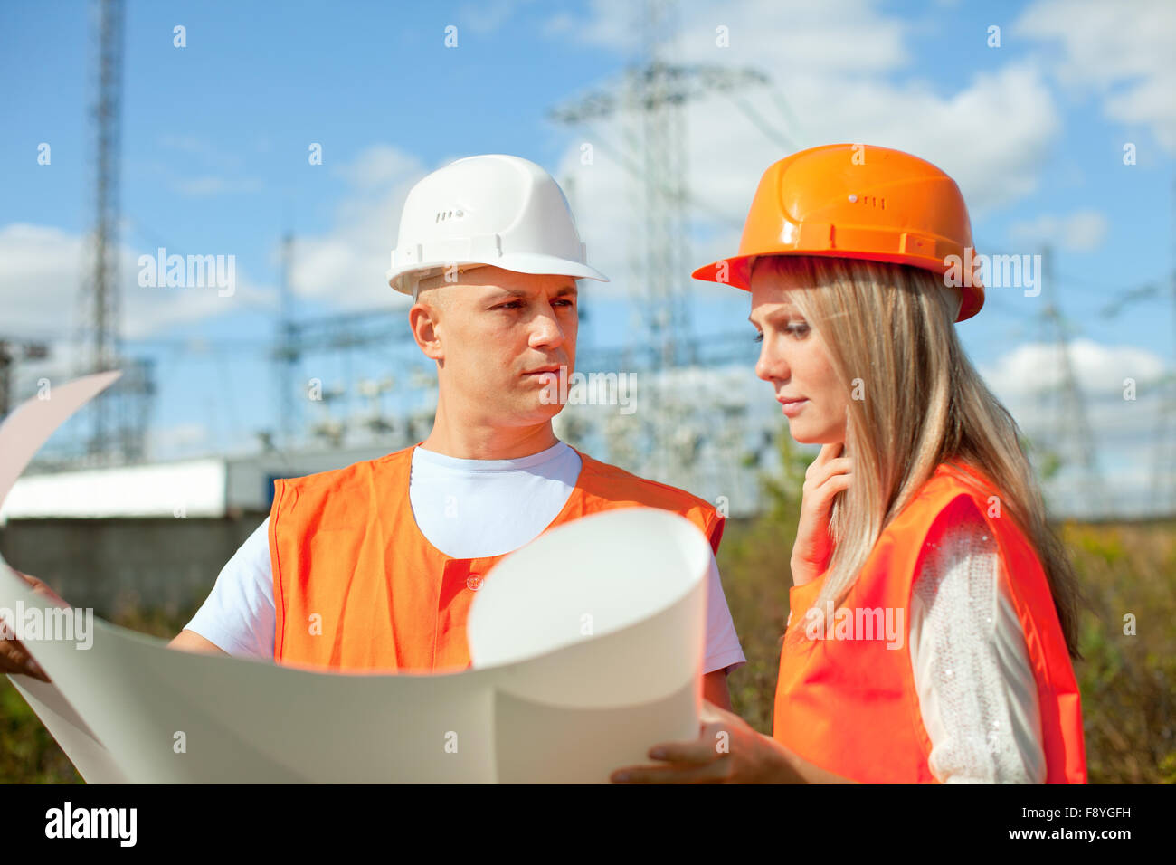 two workers wearing protective helmet works at electrical power station ...