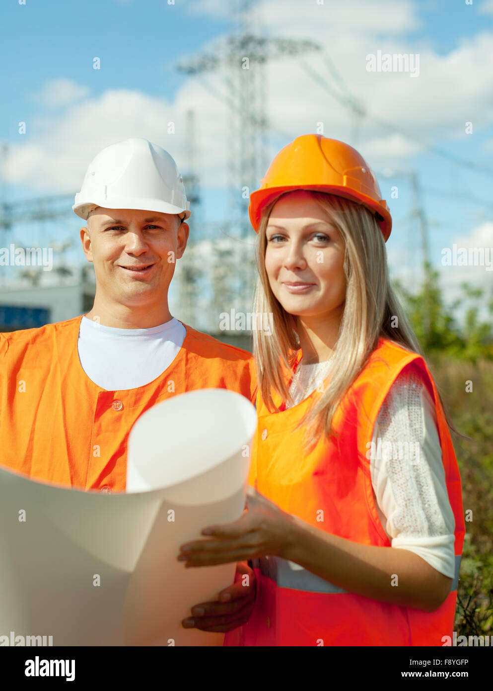 two workers wearing protective helmet works at electrical power station ...