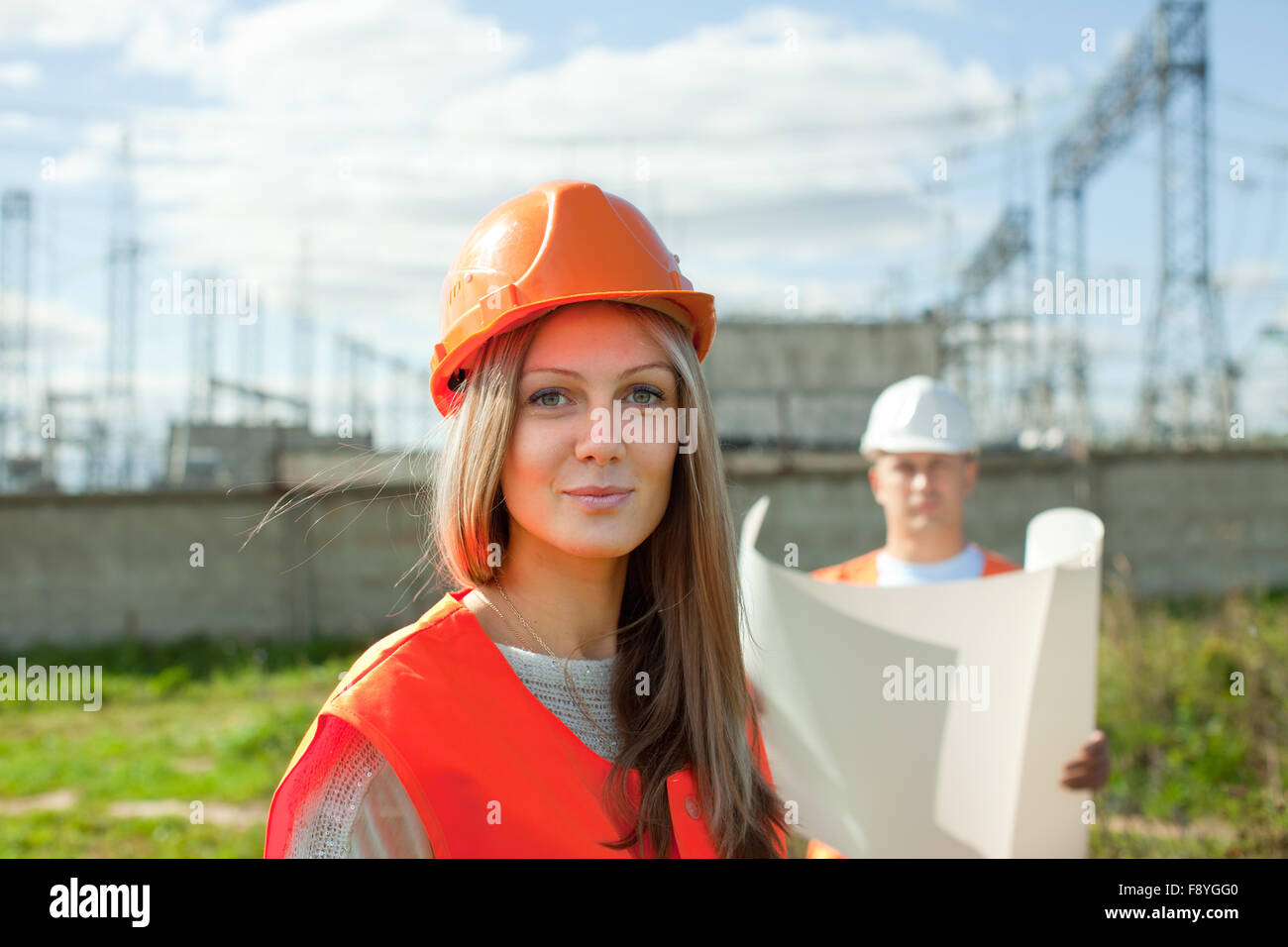 two workers wearing protective helmet works at electrical power station ...