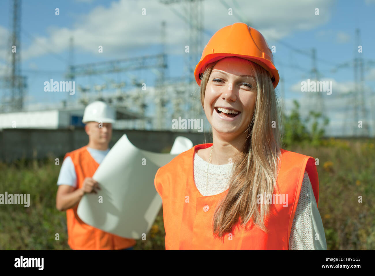 two workers wearing protective helmet works at electrical power station ...