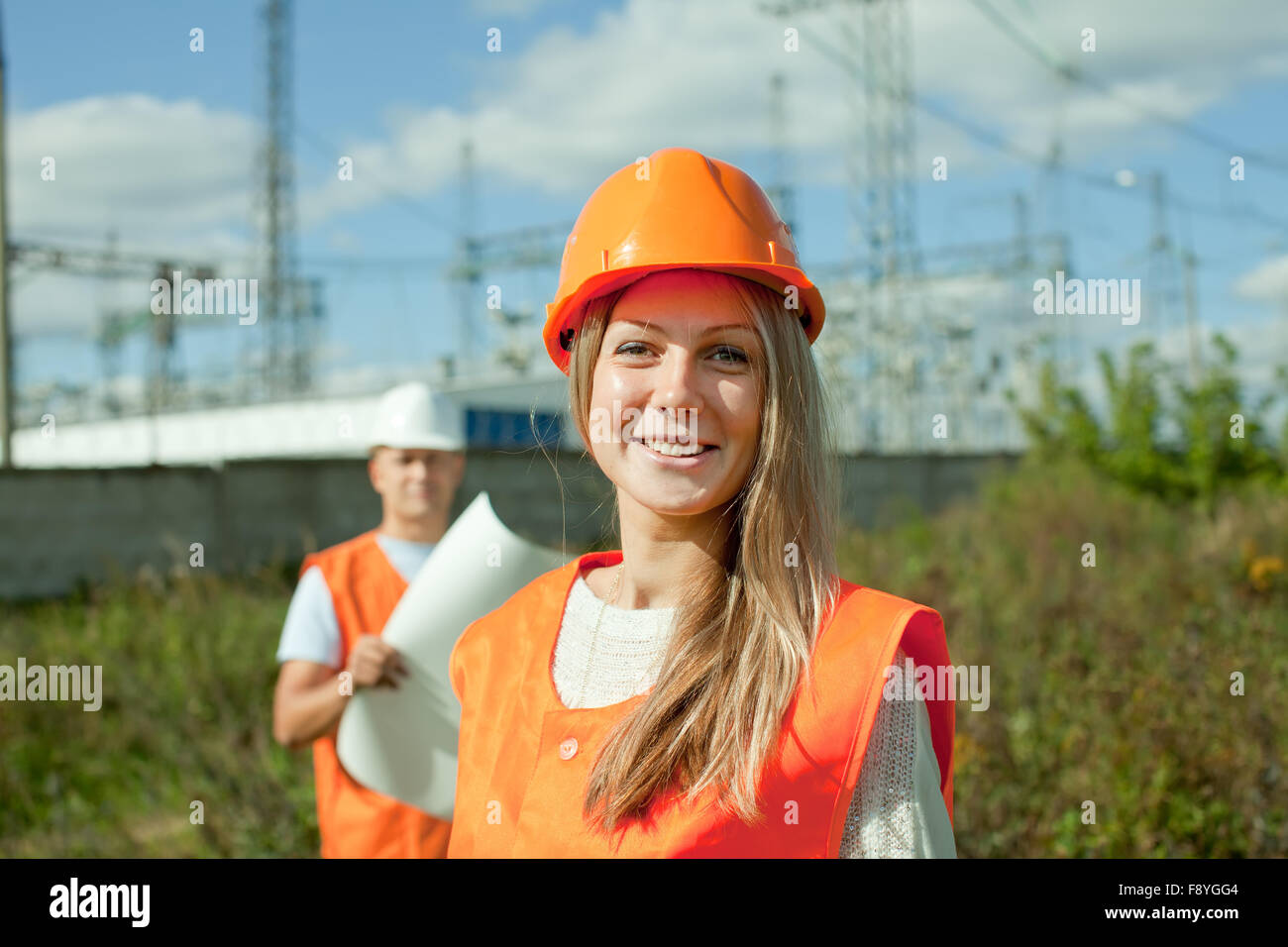 two workers wearing protective helmet works at electrical power station ...
