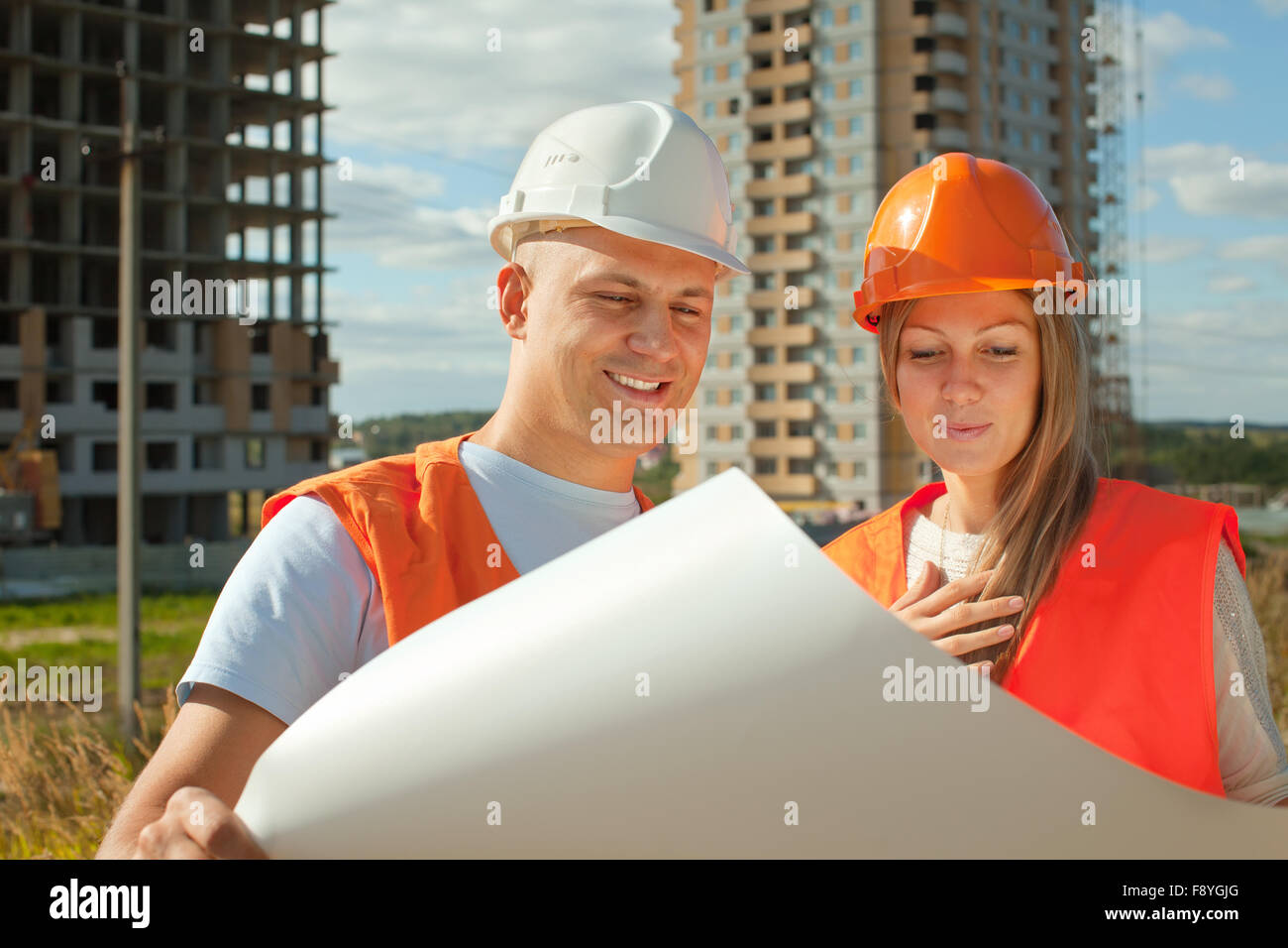 two happy builders in hardhat works on the building site Stock Photo ...