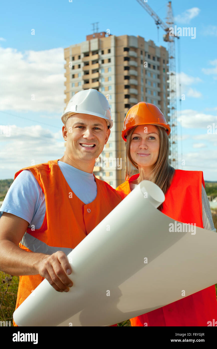 Portrait of two builders standing at building site Stock Photo - Alamy