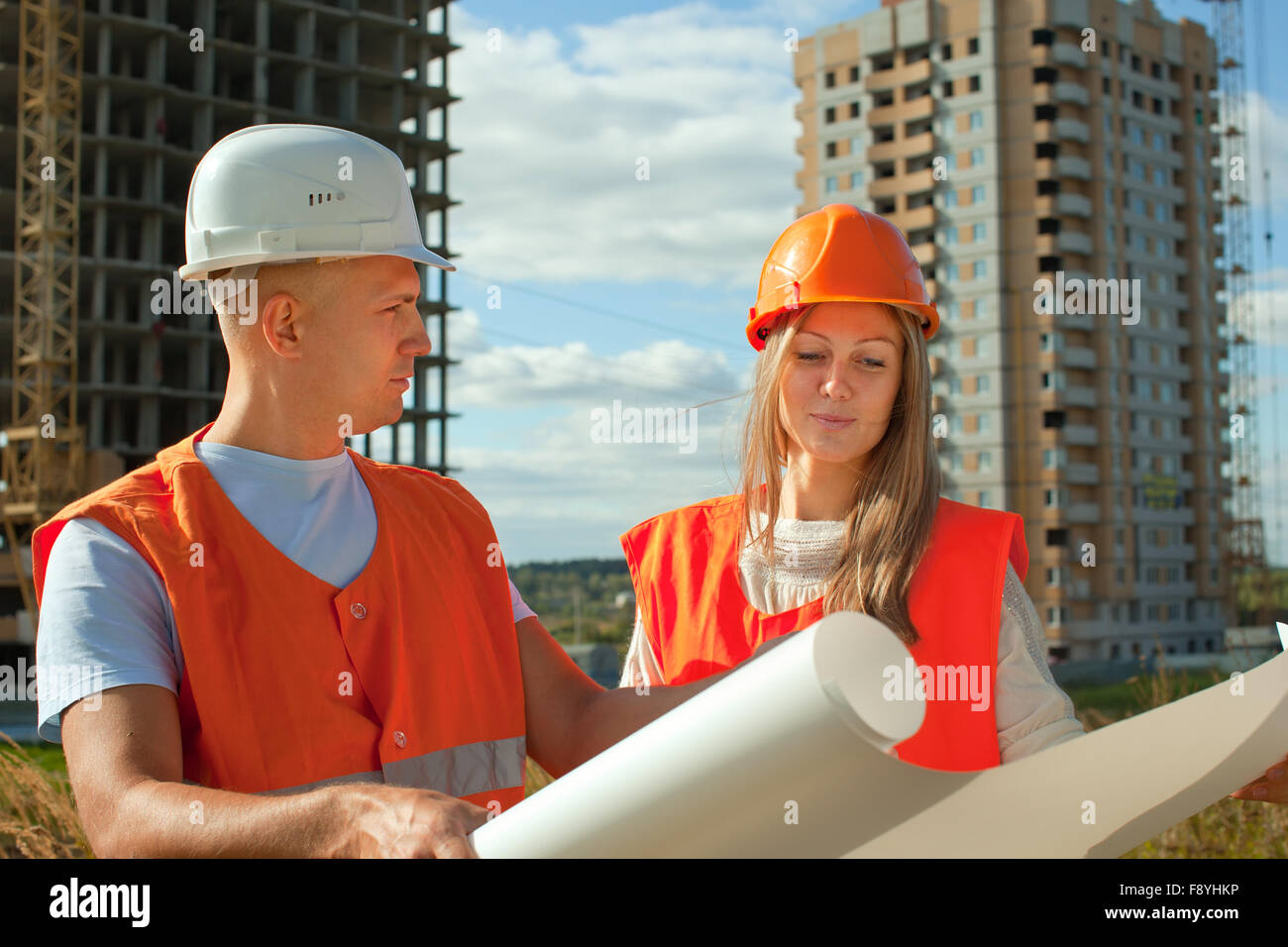 Portrait of two builders standing at building site Stock Photo - Alamy