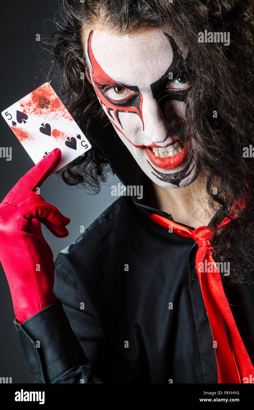 Evil clown with cards in dark room Stock Photo - Alamy