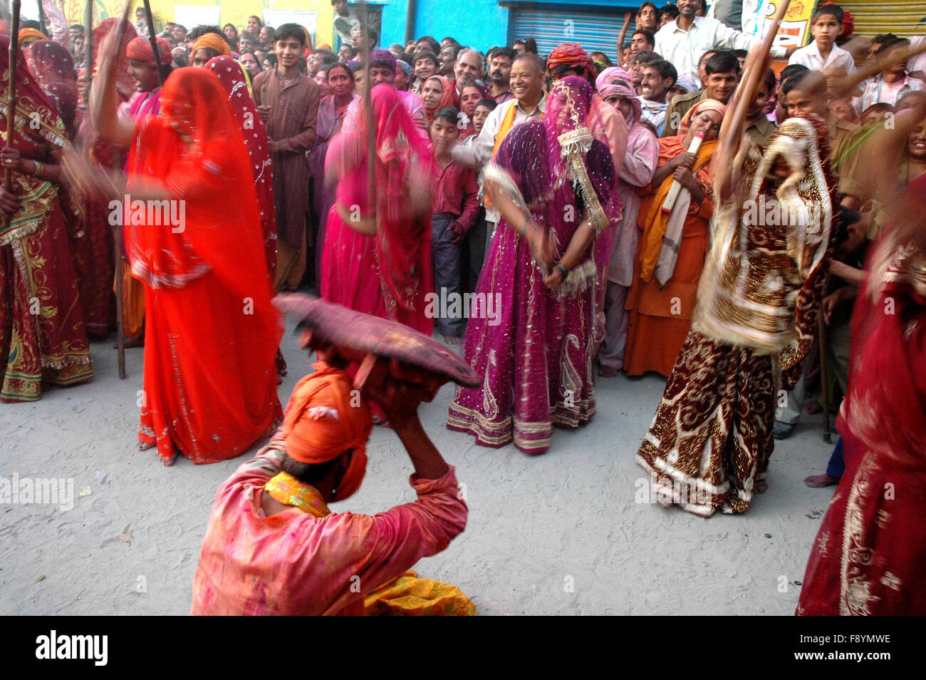 A man protecting himself and womens hitting on his shield with their ...