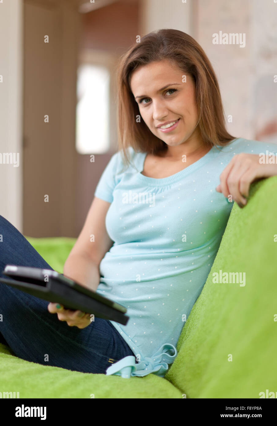 Young woman reads e-reader on sofa at home Stock Photo - Alamy