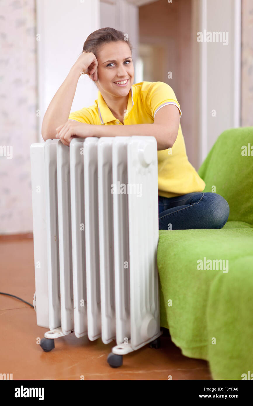 smiling woman near warm radiator in home Stock Photo - Alamy