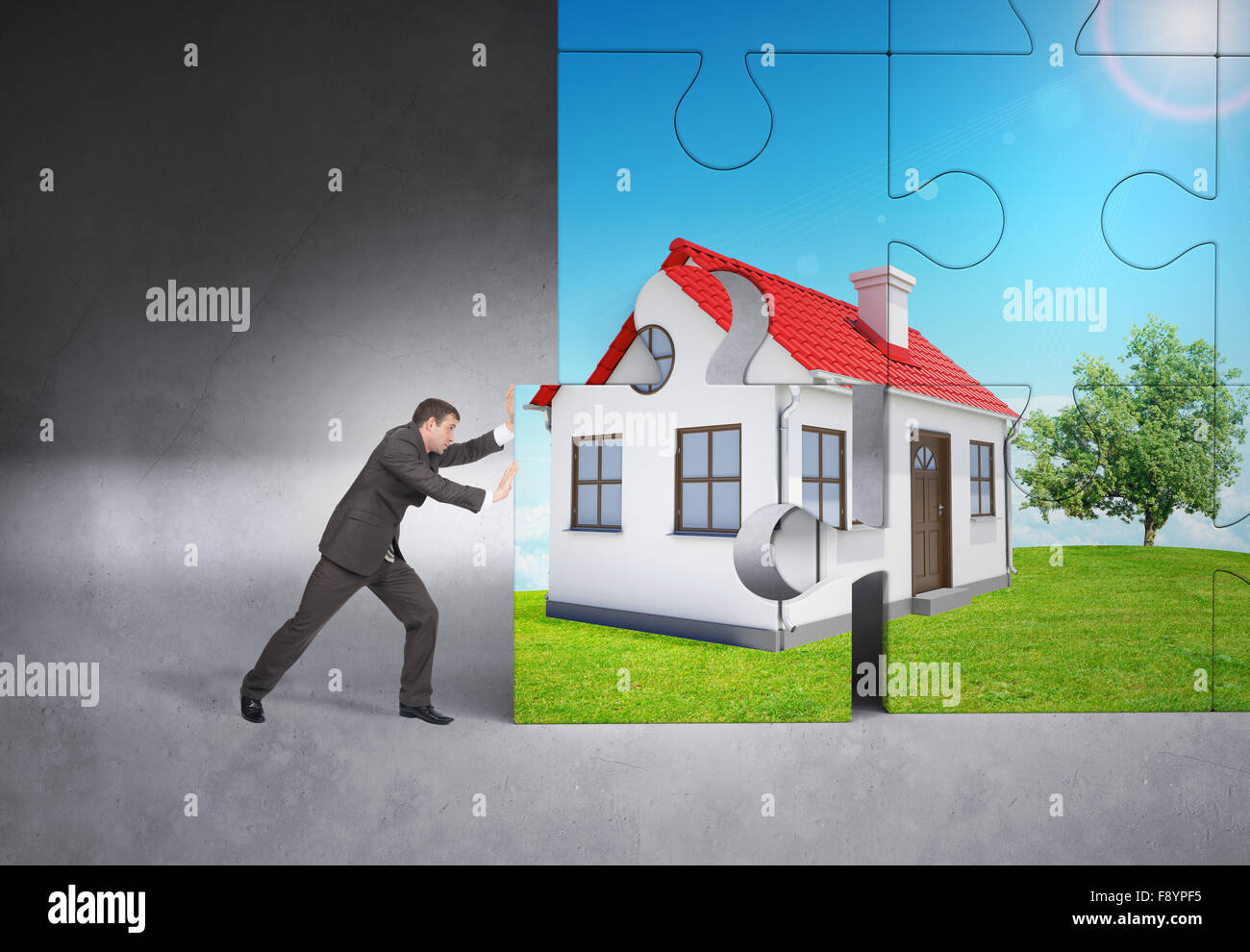 Man pushing puzzle piece of house picture Stock Photo - Alamy